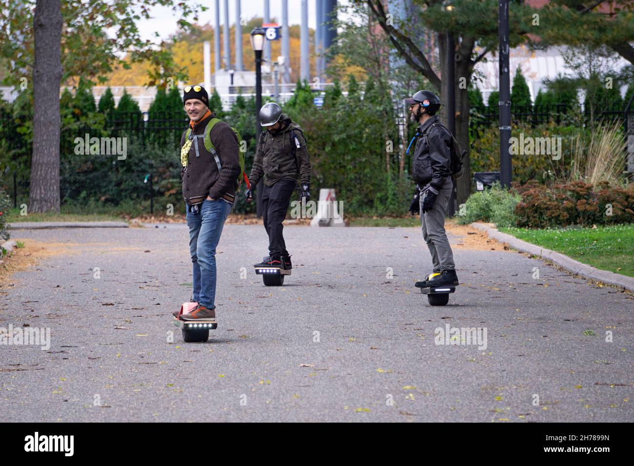 3 men, each riding a ONEWHEEL, a self-balancing single wheel electric ...