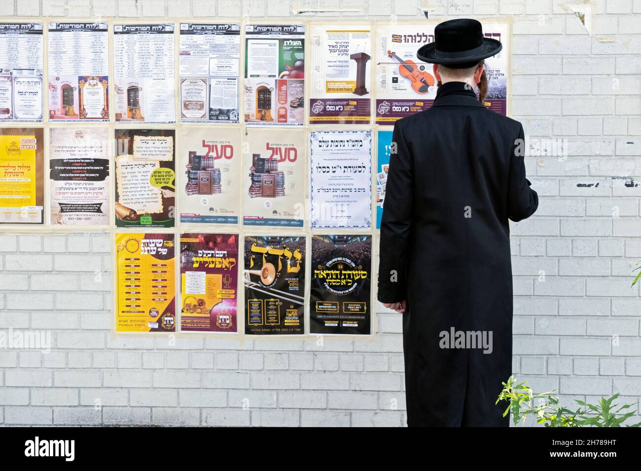 An anonymous Hasidic Jewish man reads poster announcements and ...