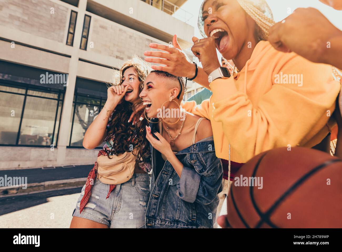 Friends laughing together outdoors. Group of generation z friends ...