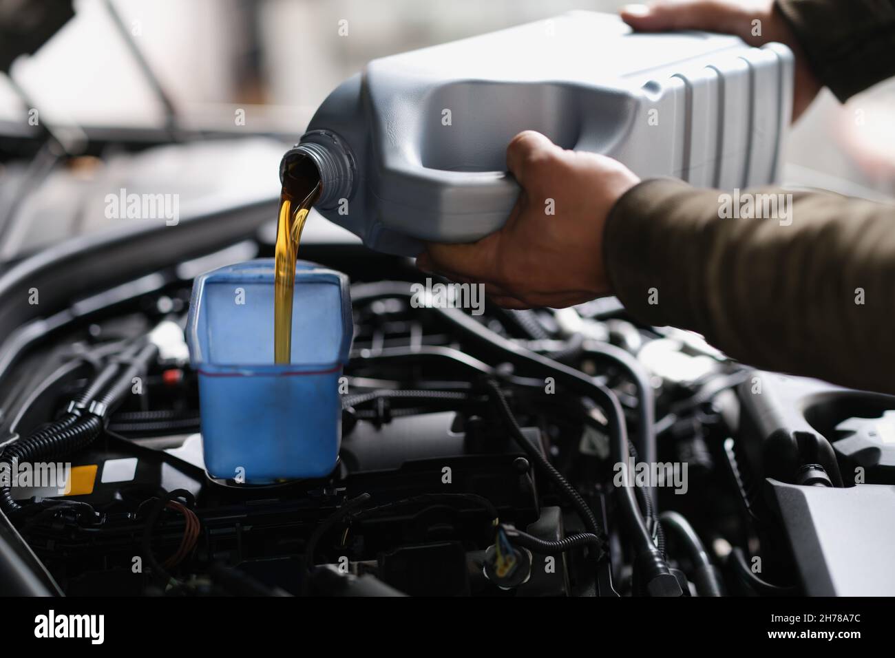 Male hands pouring machine oil from a canister Stock Photo - Alamy