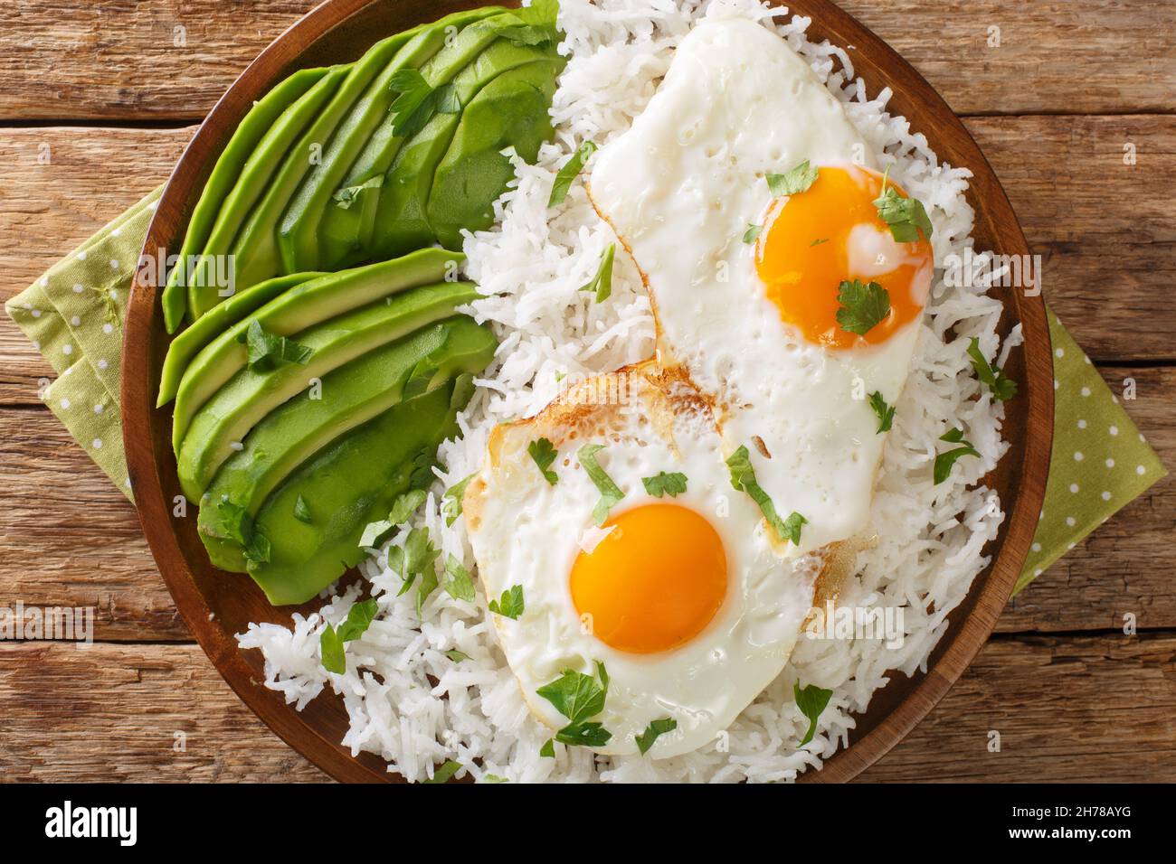 Latin American food of boiled rice and fried eggs close-up in a plate ...