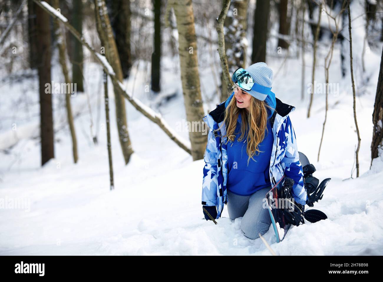 image with a portrait of a female snowboarder wearing a helmet with a bright reflection in the ...