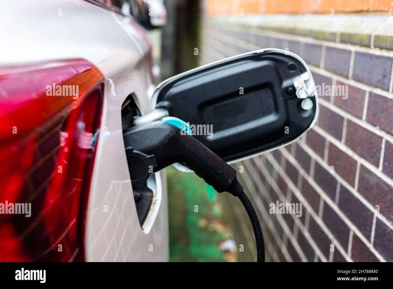 Electric car charging at plug in charge station in a public car park in ...