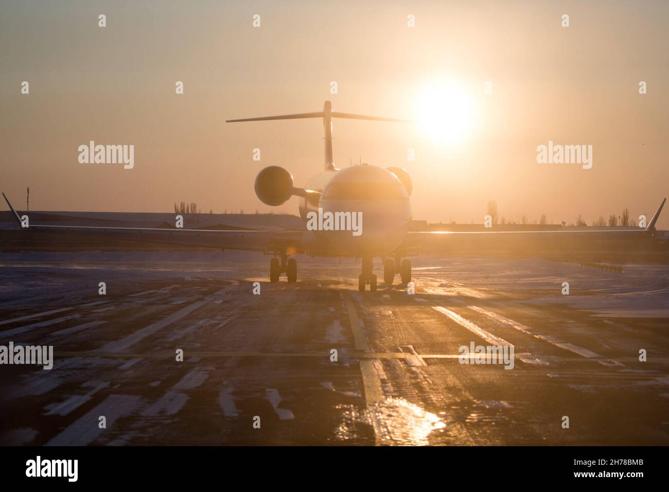 Plane in back rays of sunset. Passenger aircraft on runway in rays of ...
