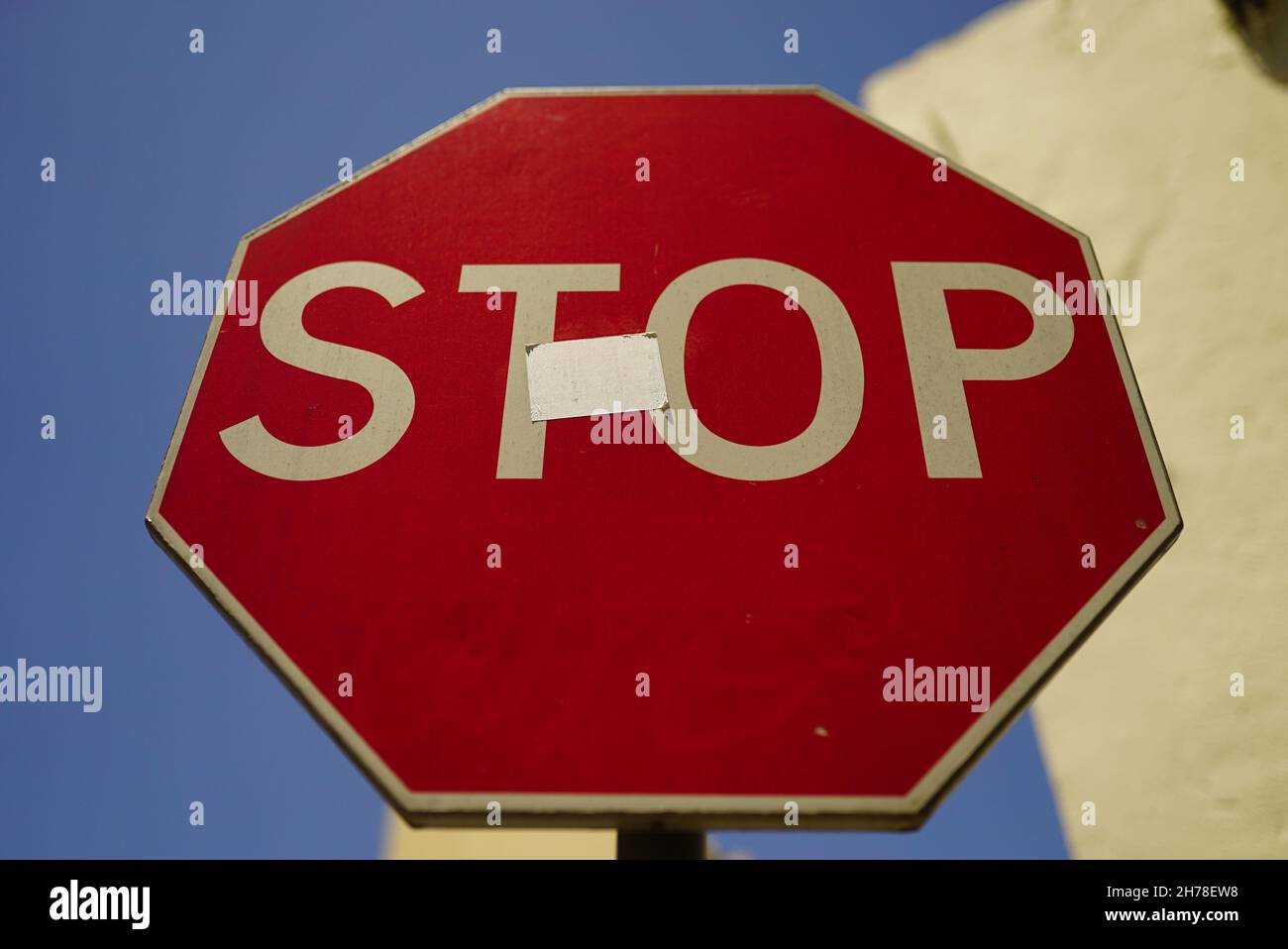 A low angle shot of the street sign "STOP" on a red board with blurry ...