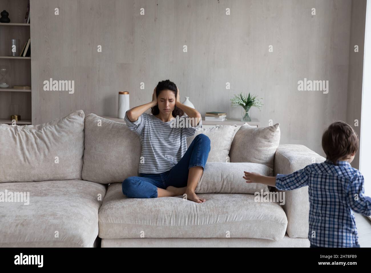 Disobedient boy running in living room and disturb mother Stock Photo ...