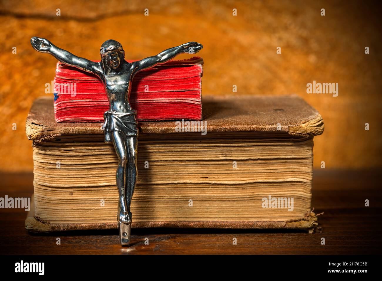 Silver crucifix without the cross and two Holy Bibles on a wooden table ...