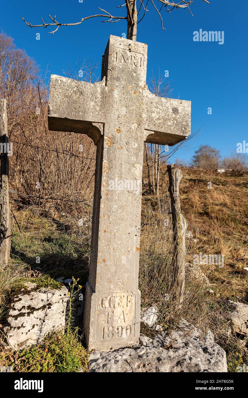 Stone cross (Christian symbol) with INRI inscription in the countryside ...