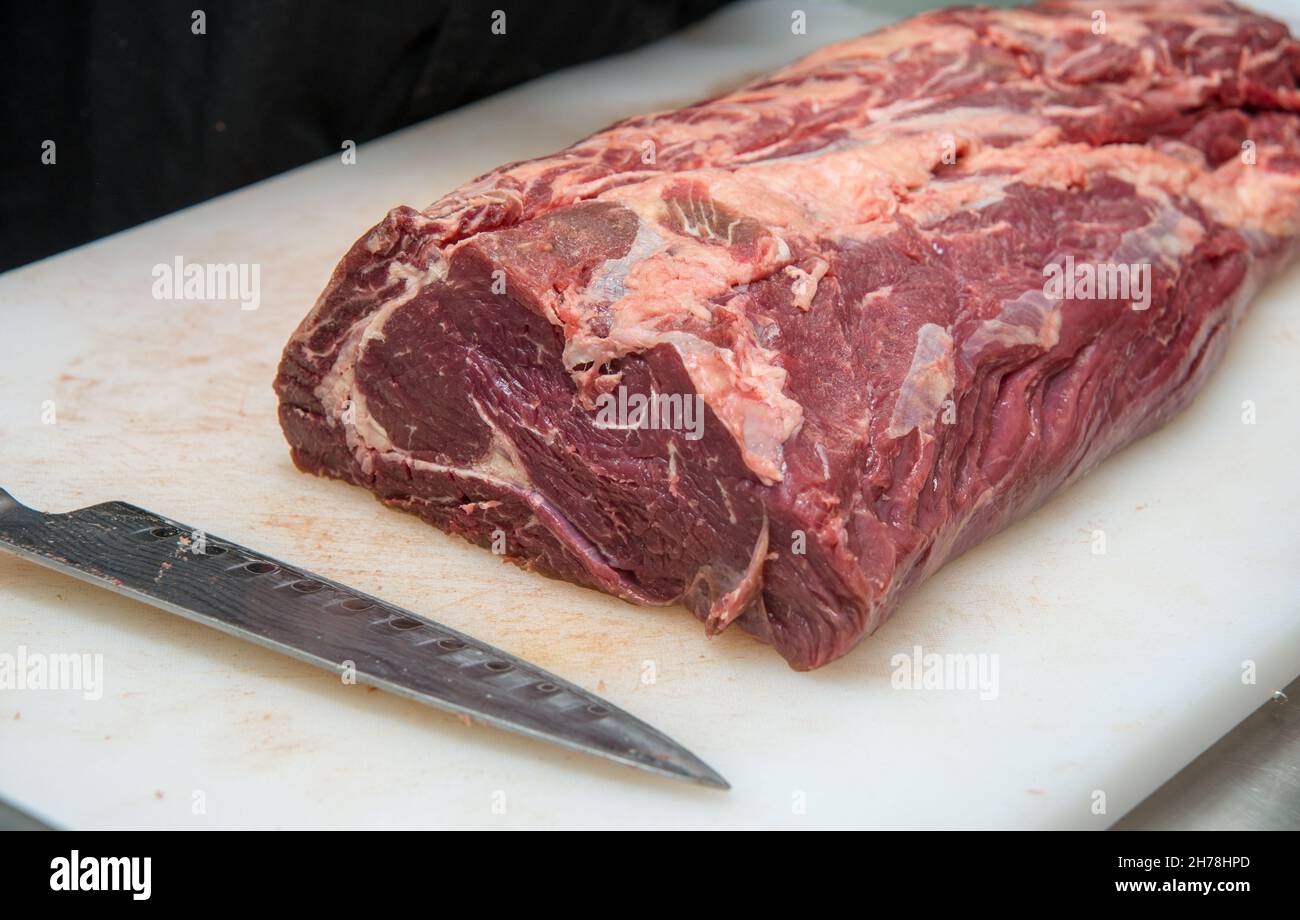 Cheff cuts a beef cut to size Stock Photo - Alamy