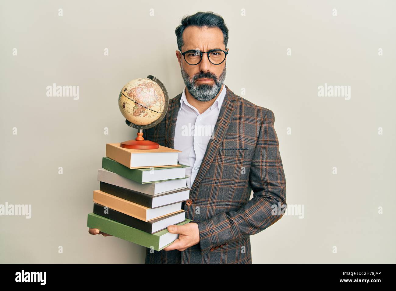 Middle age man with beard and grey hair teacher holding vintage world ...