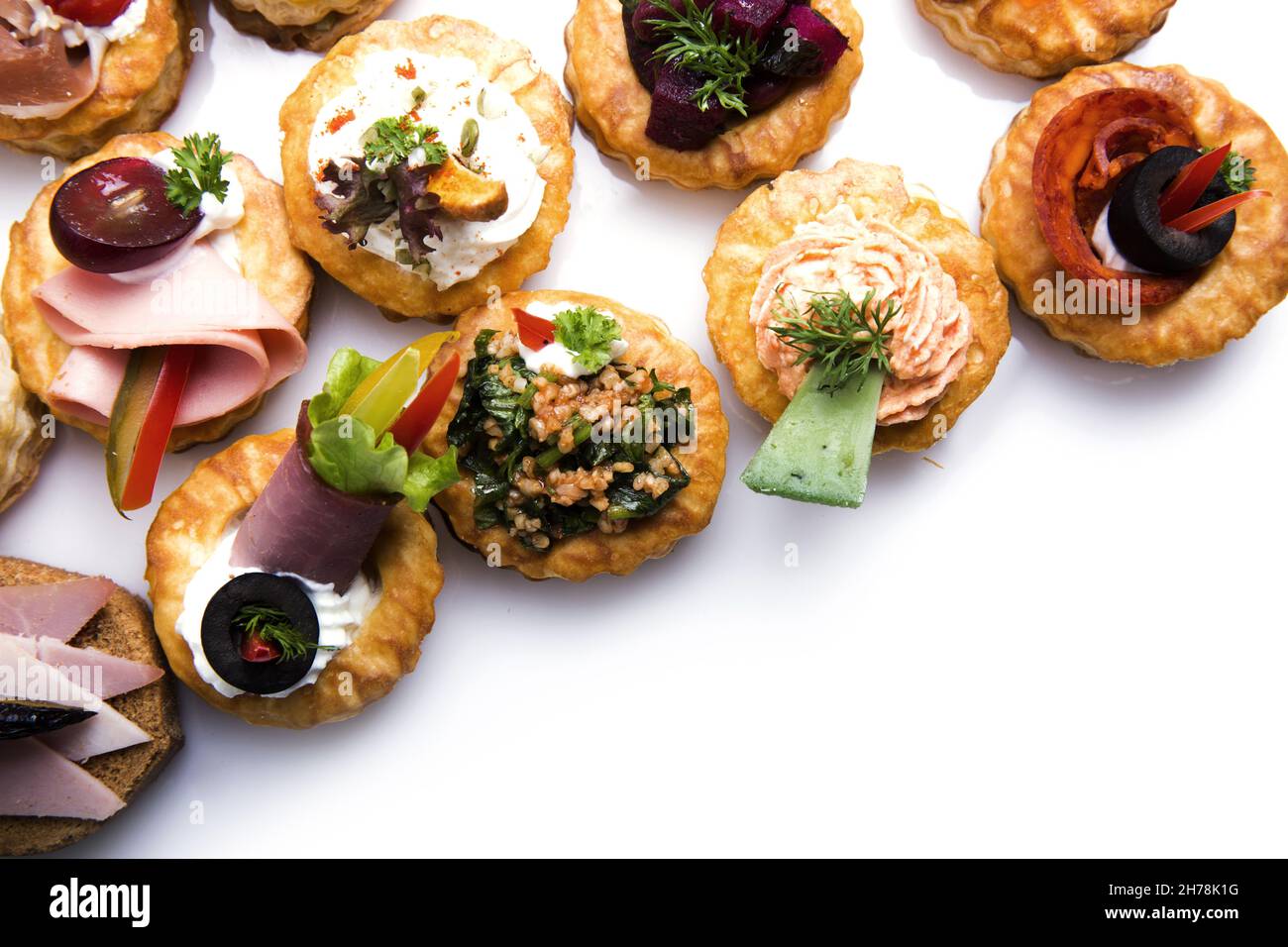 A top view of canapes with different ingredients on a white background ...