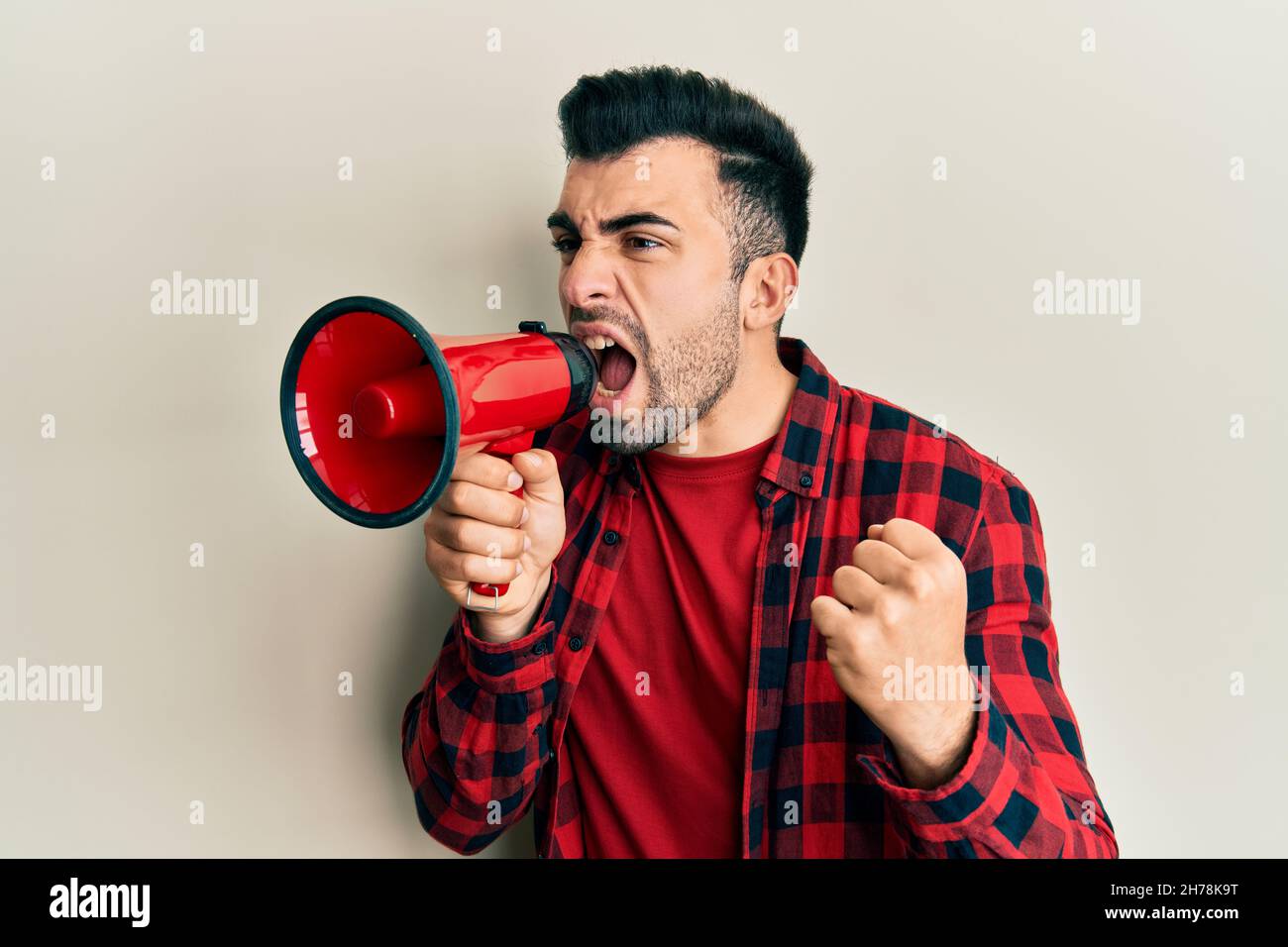 Hispanic man with beard screaming with megaphone Stock Photo - Alamy