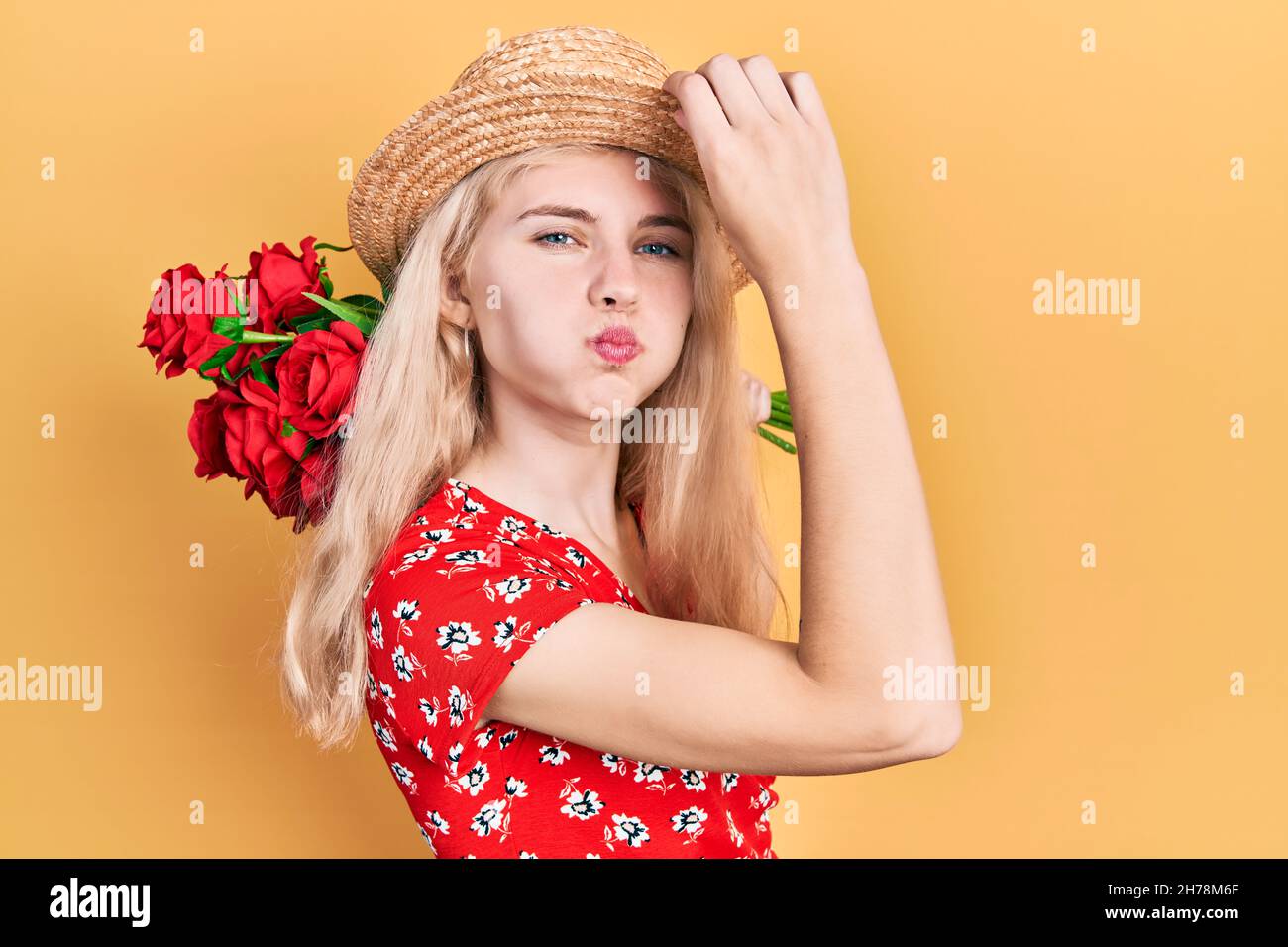 Beautiful caucasian woman with blond hair holding bouquet of red roses ...