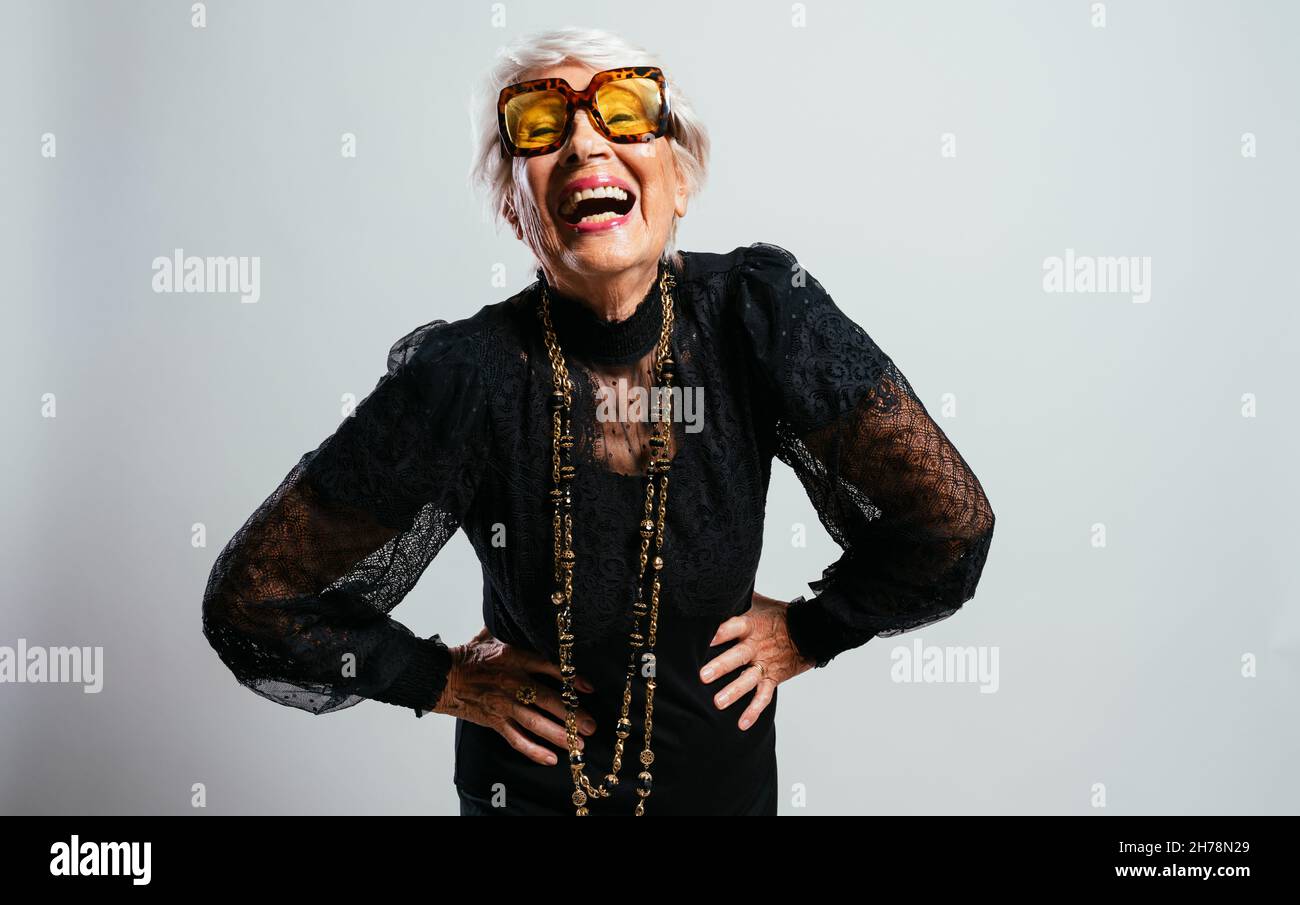 Beautiful and elegant old influencer woman. Cool grandmother posing in ...