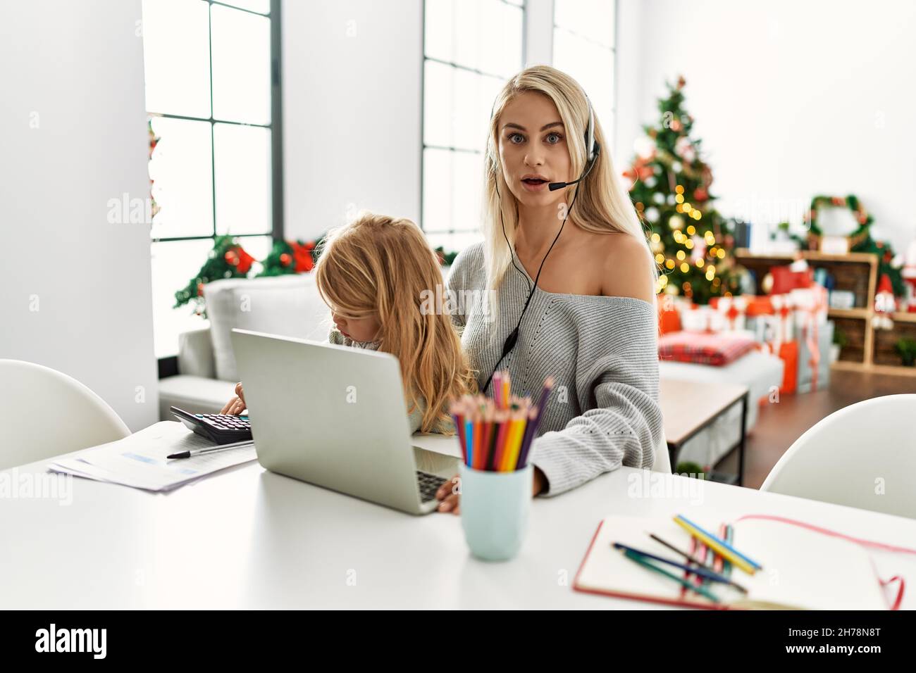 Mother of caucasian daughter wearing call center agent headset at home ...