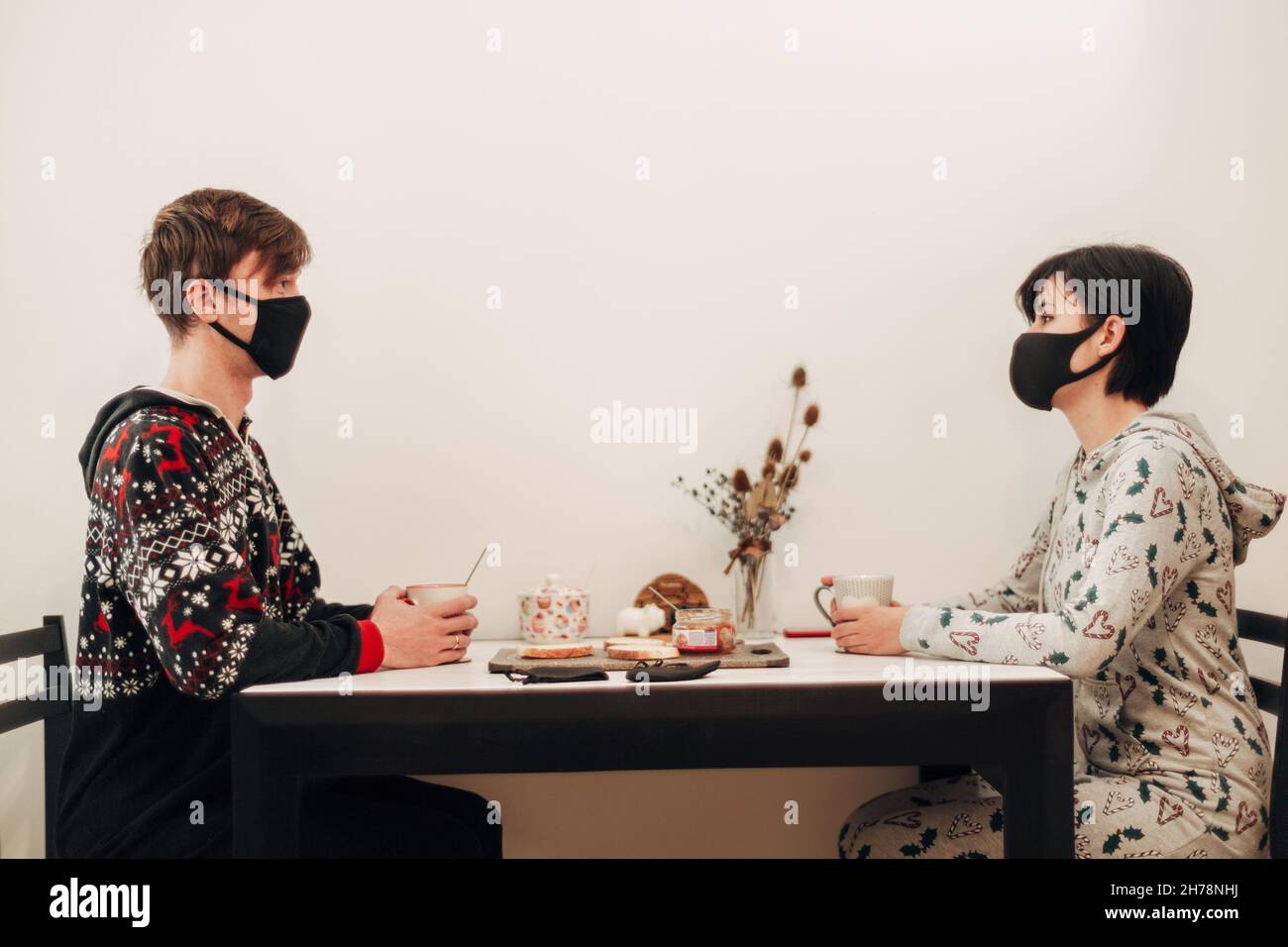 Girl and Guy Drinking Tea at Home in Masks Stock Photo - Alamy