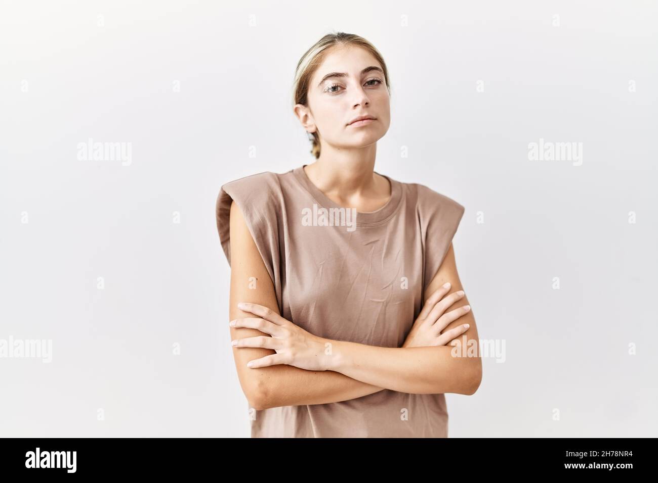 Young blonde woman standing over isolated background skeptic and ...