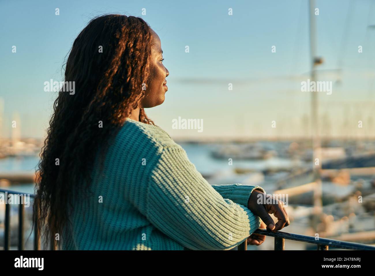 Young african woman smiling happy by marina port Stock Photo - Alamy
