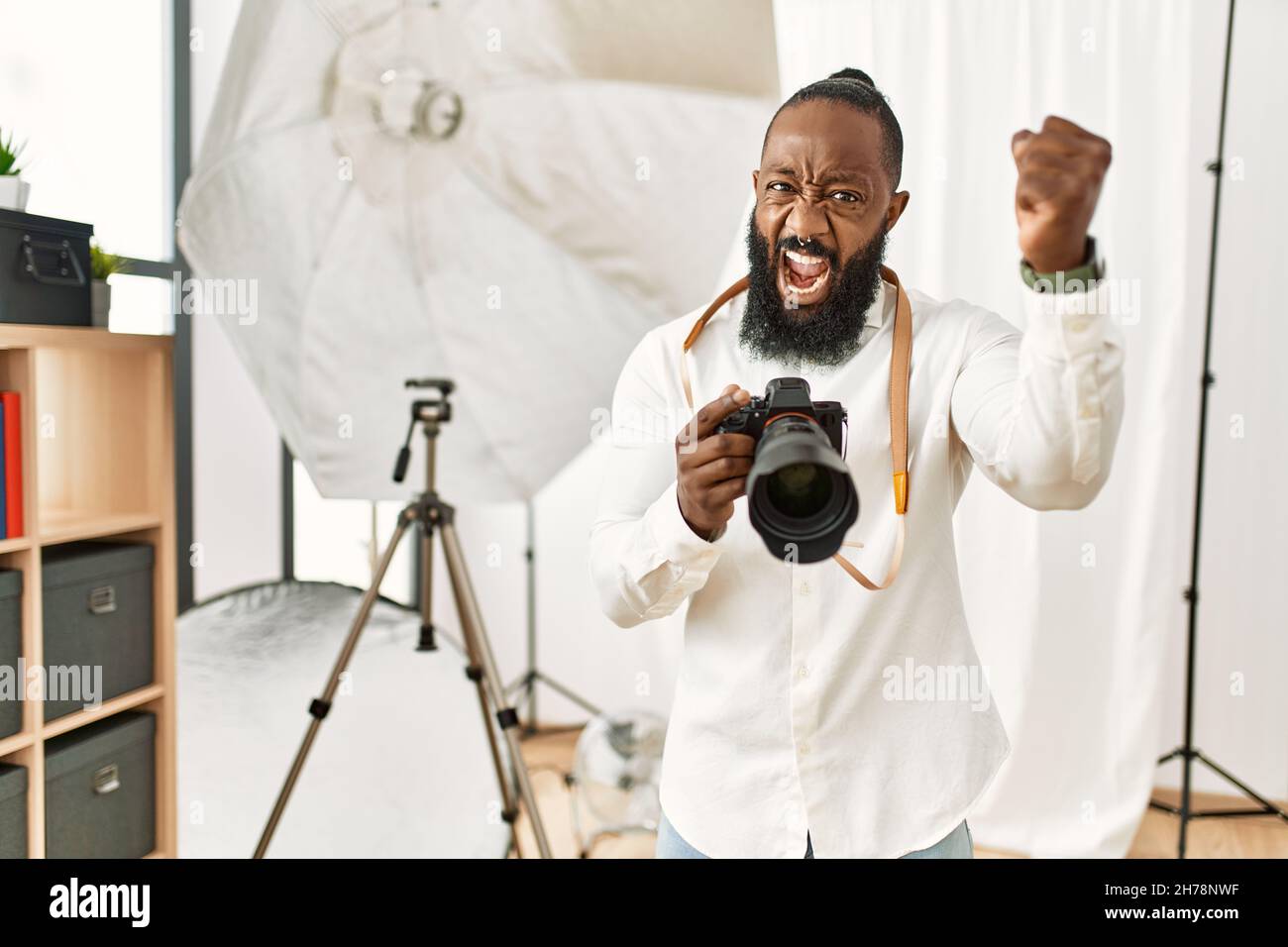 African american photographer man working at photography studio angry ...
