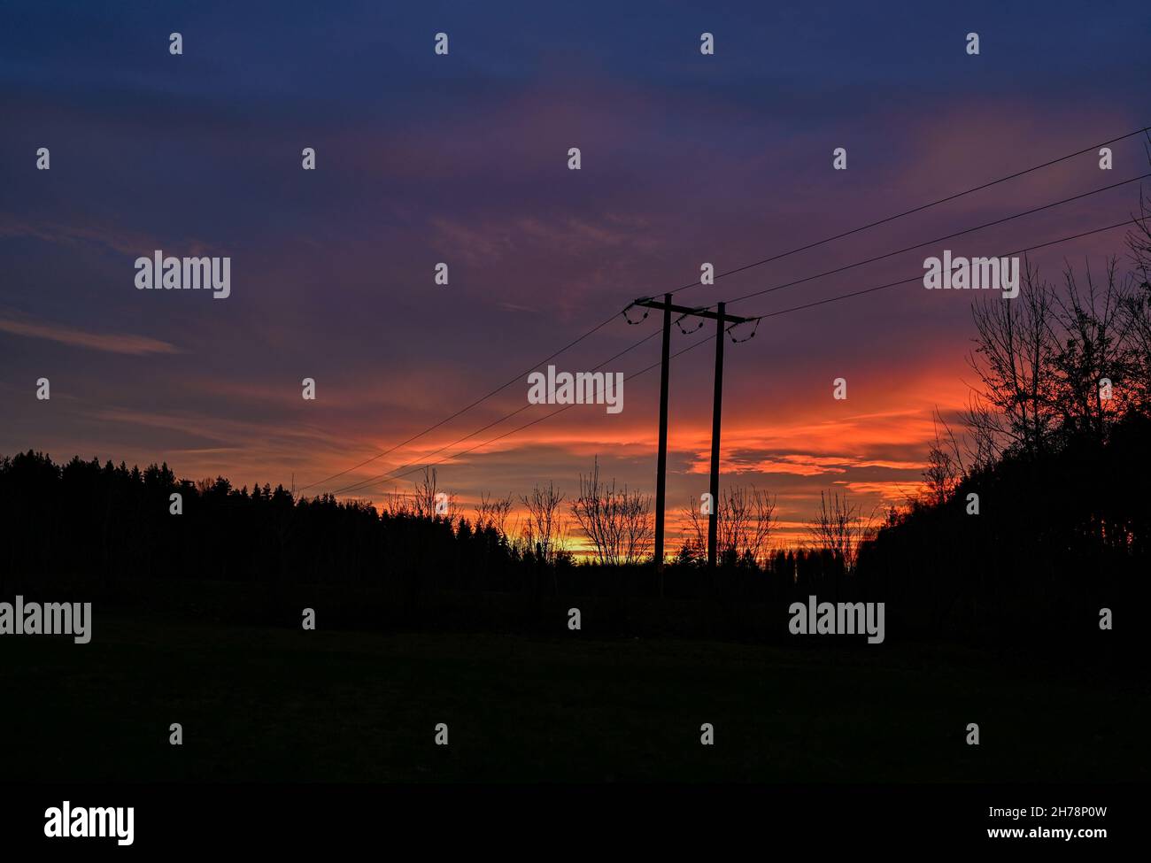 powerline infront of orange sunset with clouds Stock Photo - Alamy
