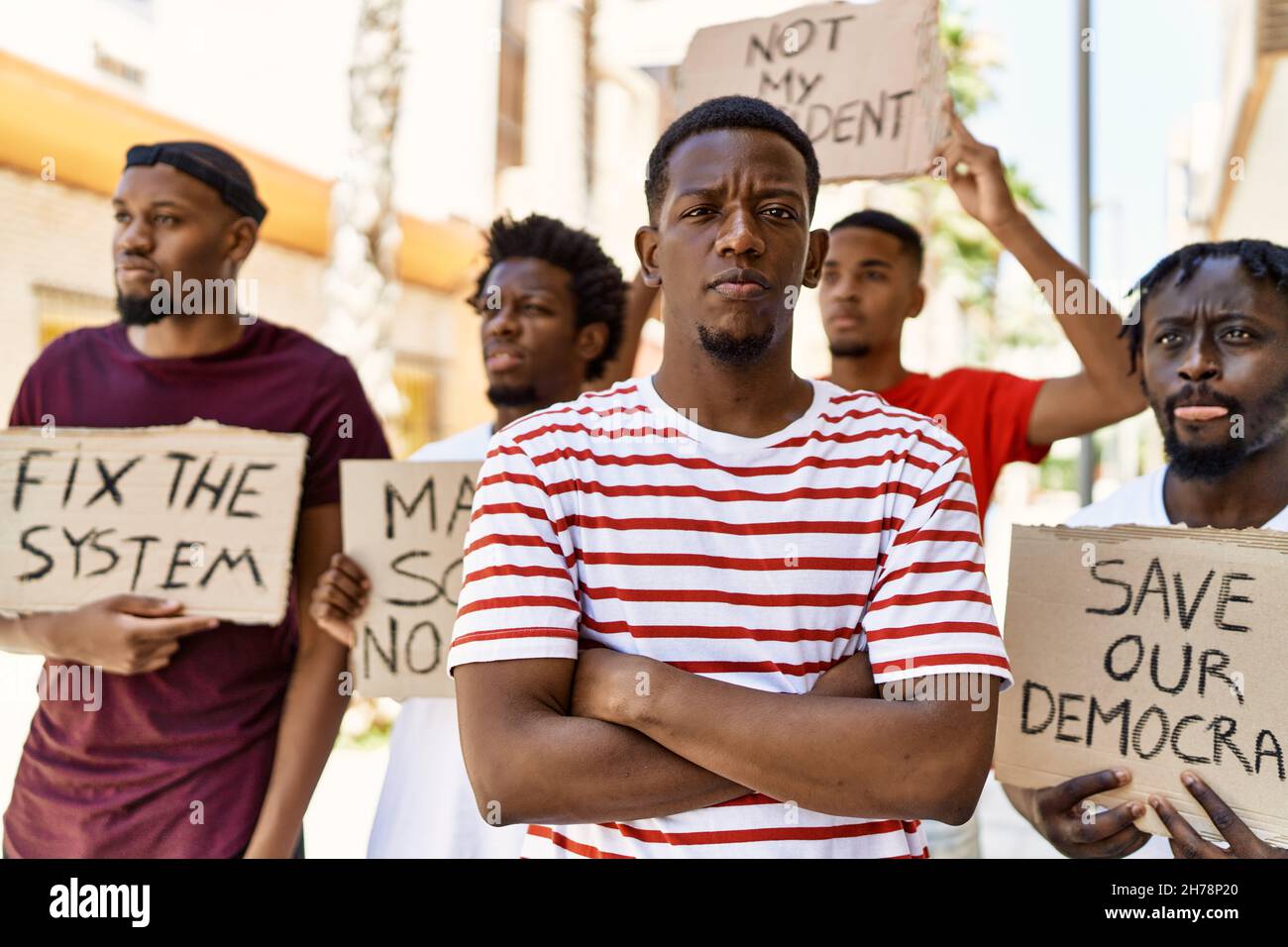 Young activist man with arms crossed gesture standing with a group of ...