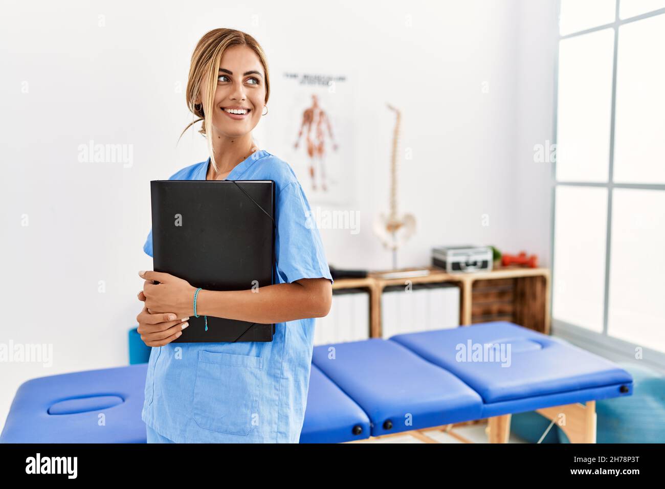 Young caucasian physio therapist smiling happy holding binder at the ...