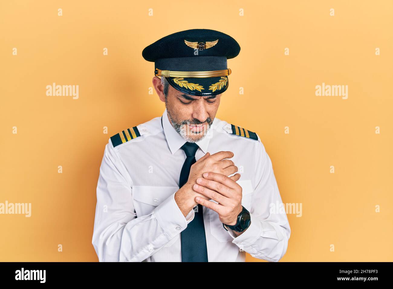 Handsome middle age man with grey hair wearing airplane pilot uniform ...