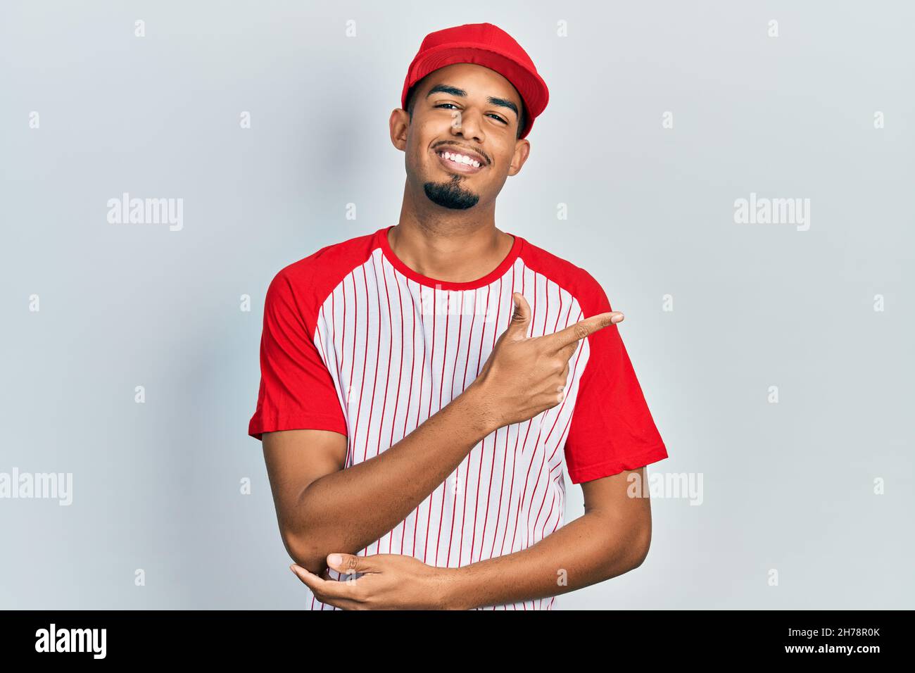 Young african american man wearing baseball uniform looking positive ...