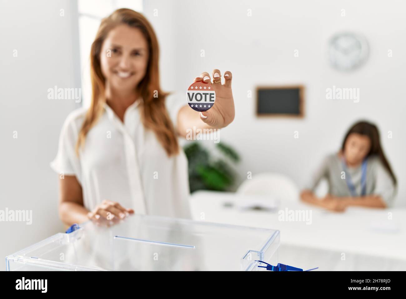 Mother and daughter smiling confident holding vote badge at electoral ...