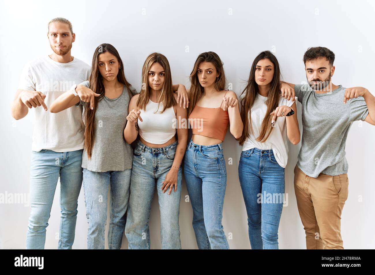 Group of young friends standing together over isolated background ...