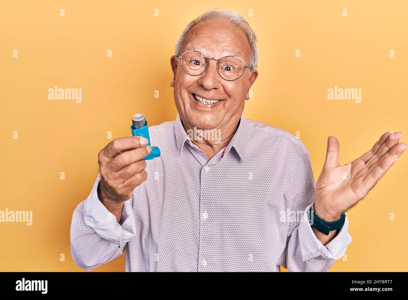 Senior man with grey hair holding medical asthma inhaler celebrating ...