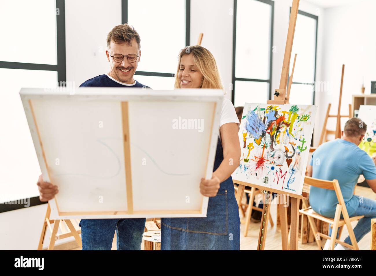 Group of middle age people drawing at art studio. Two students smiling ...
