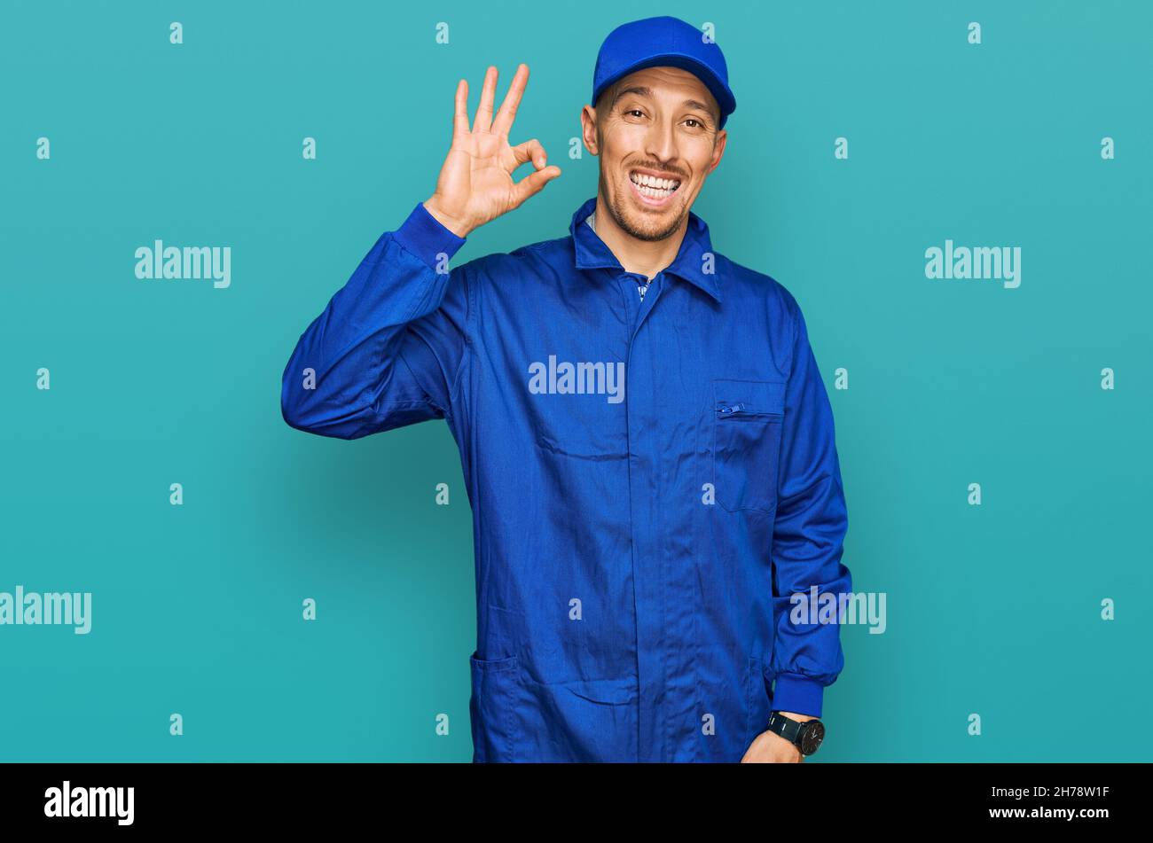 Bald man with beard wearing builder jumpsuit uniform smiling positive ...