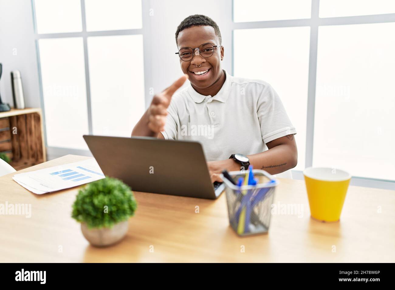 Young african man working at the office using computer laptop smiling ...