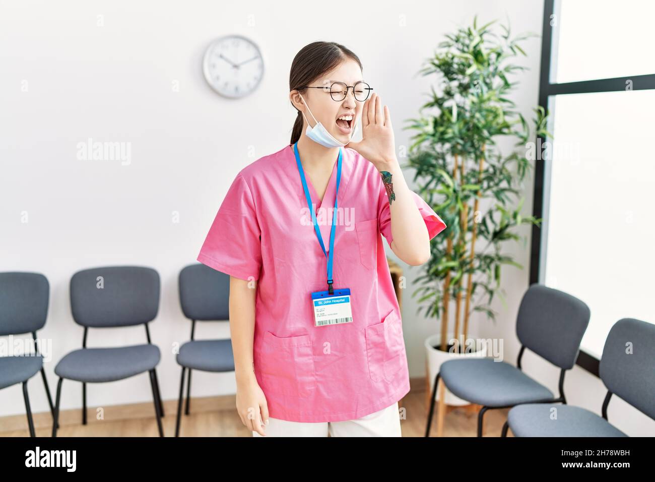 Young asian nurse woman at medical waiting room shouting and screaming ...