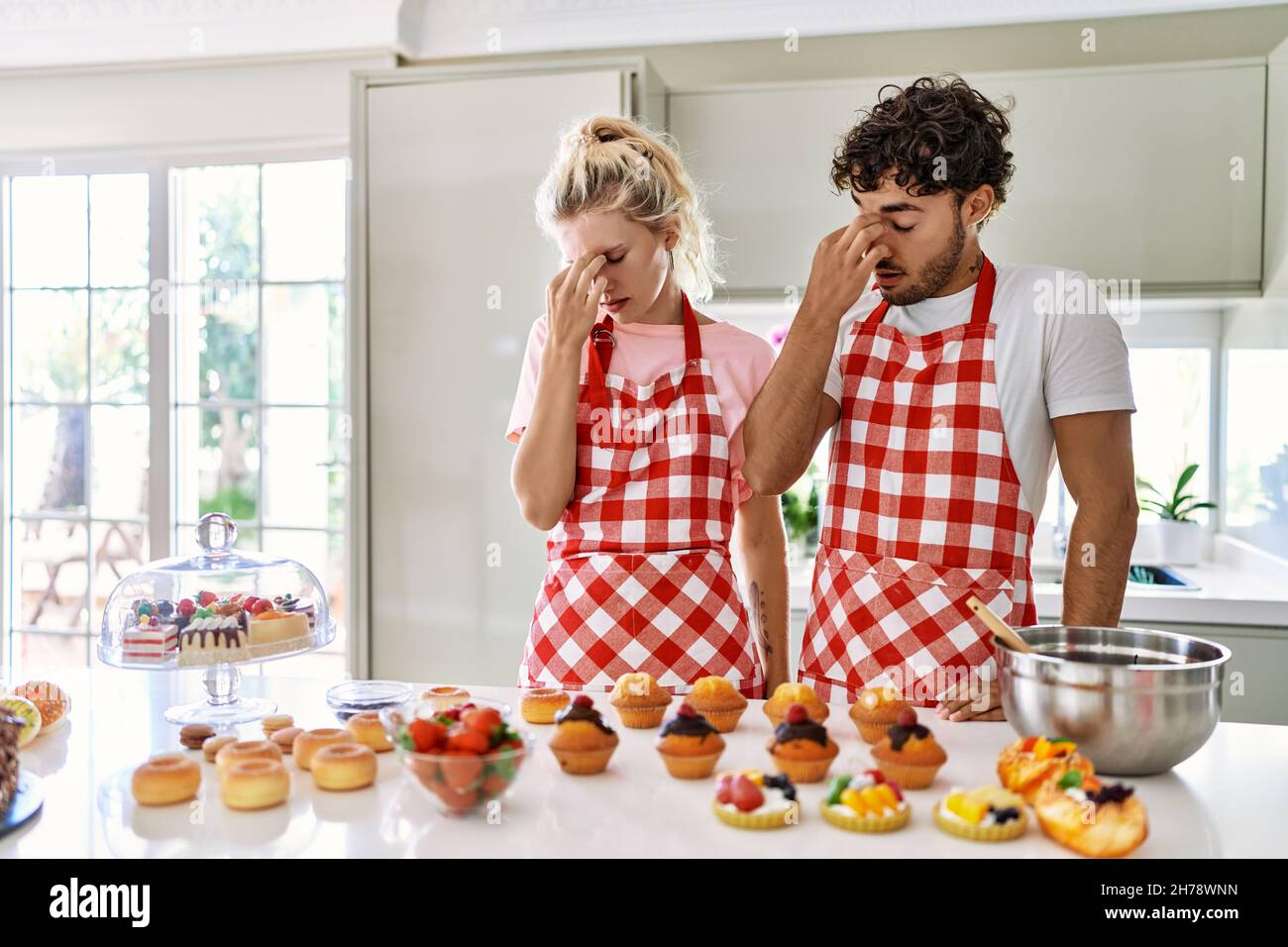 Couple of wife and husband cooking pastries at the kitchen tired ...