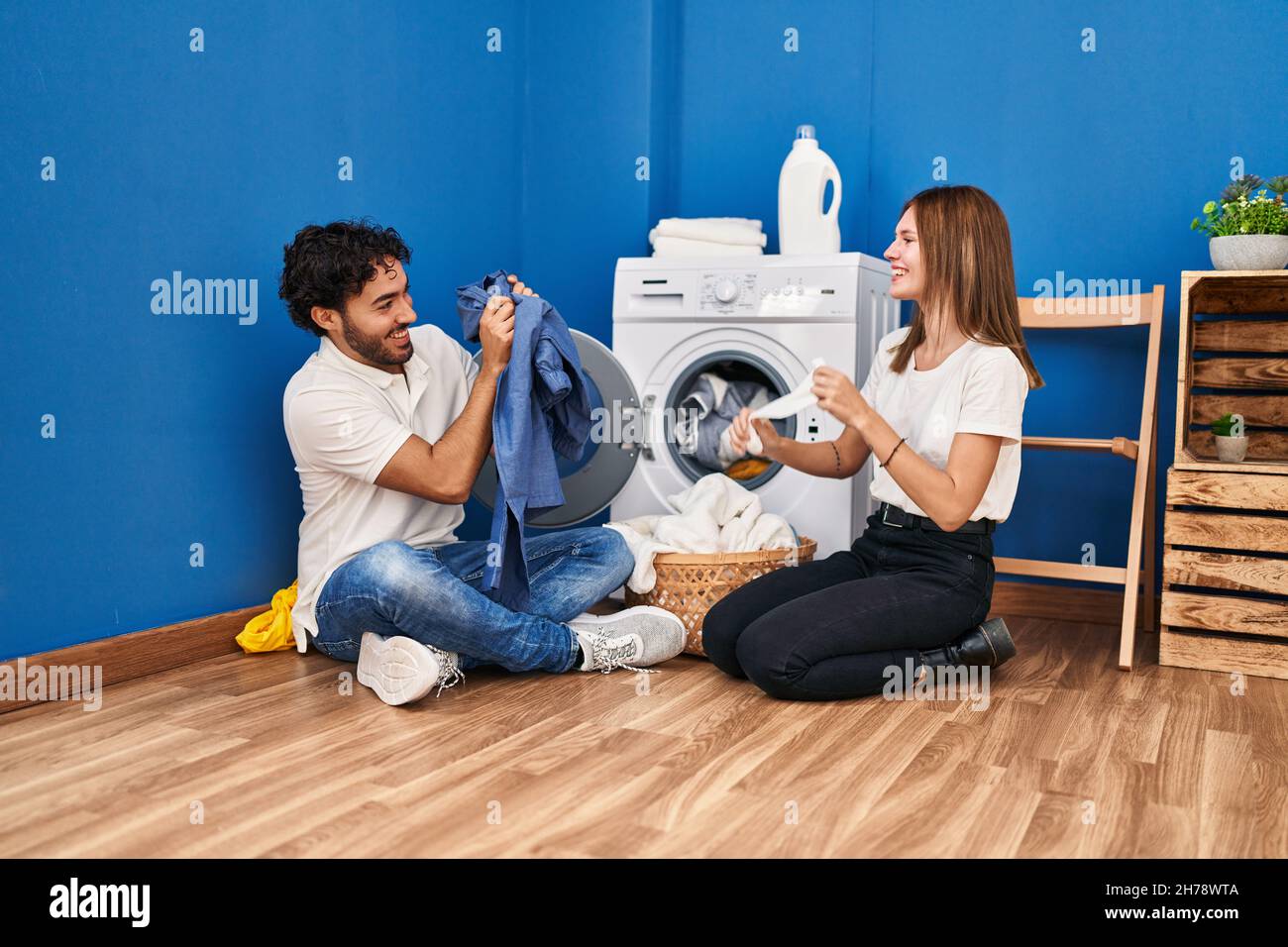 Man and woman couple smiling confident playing with cleaning clothes at laundry room Stock Photo ...