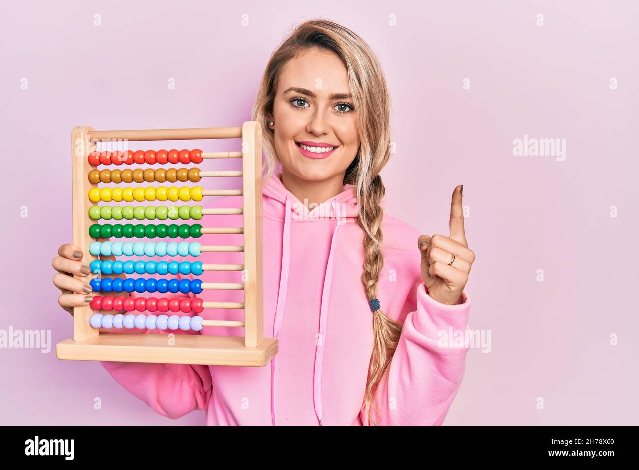 Beautiful young blonde woman holding traditional abacus smiling with an ...