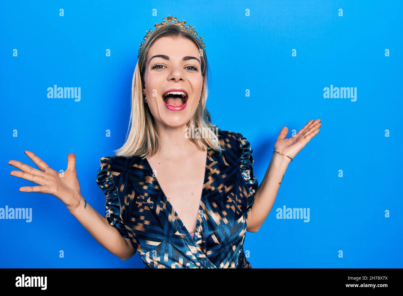 Beautiful caucasian woman wearing princess crown celebrating mad and ...