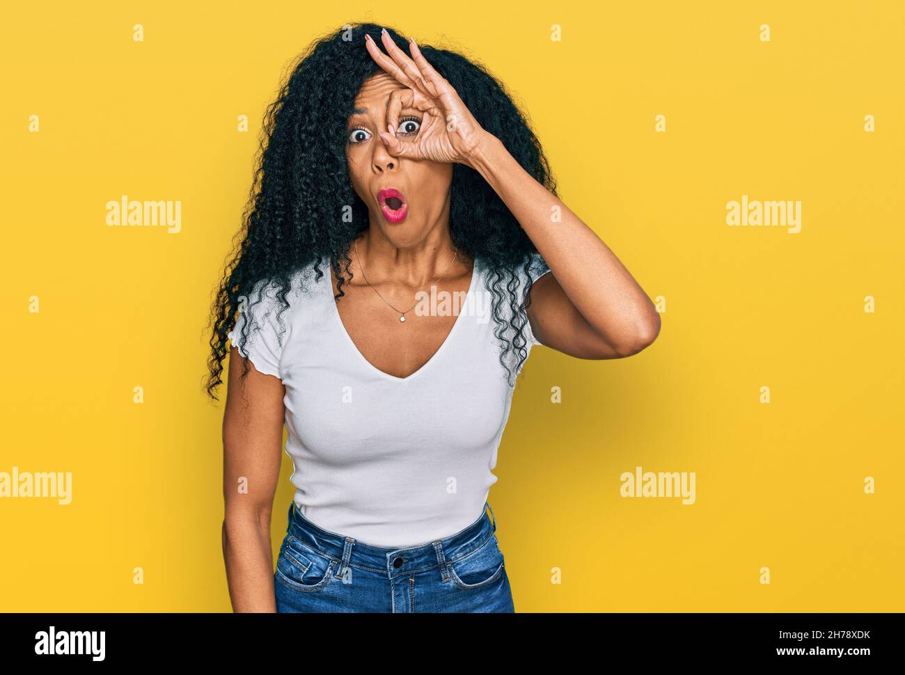 Middle age african american woman wearing casual white t shirt doing ok ...