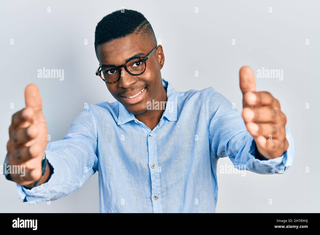 Young african american man wearing casual clothes and glasses looking ...