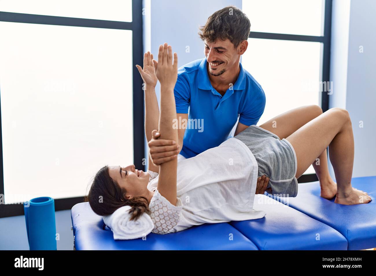 Man and woman wearing physiotherpy uniform having rehab session at ...