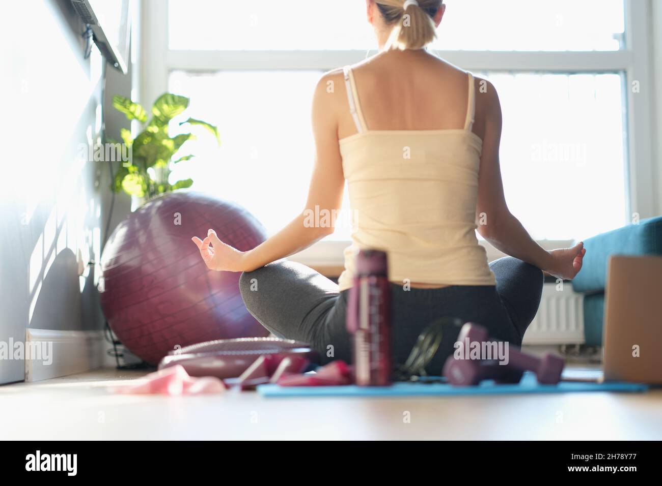 Woman sitting in front of window in yoga pose Stock Photo - Alamy