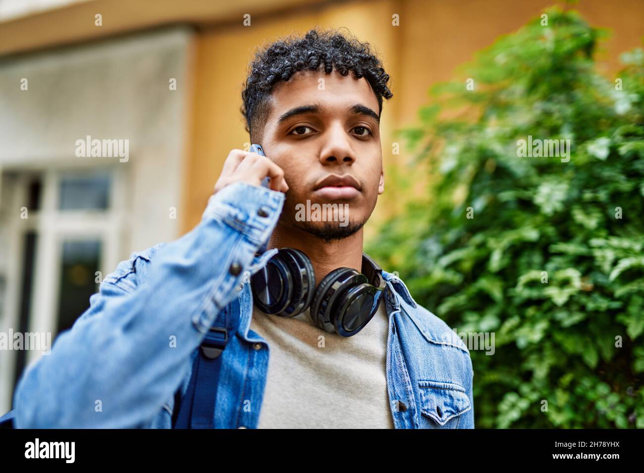 Hispanic young man speaking on the phone at the street Stock Photo - Alamy