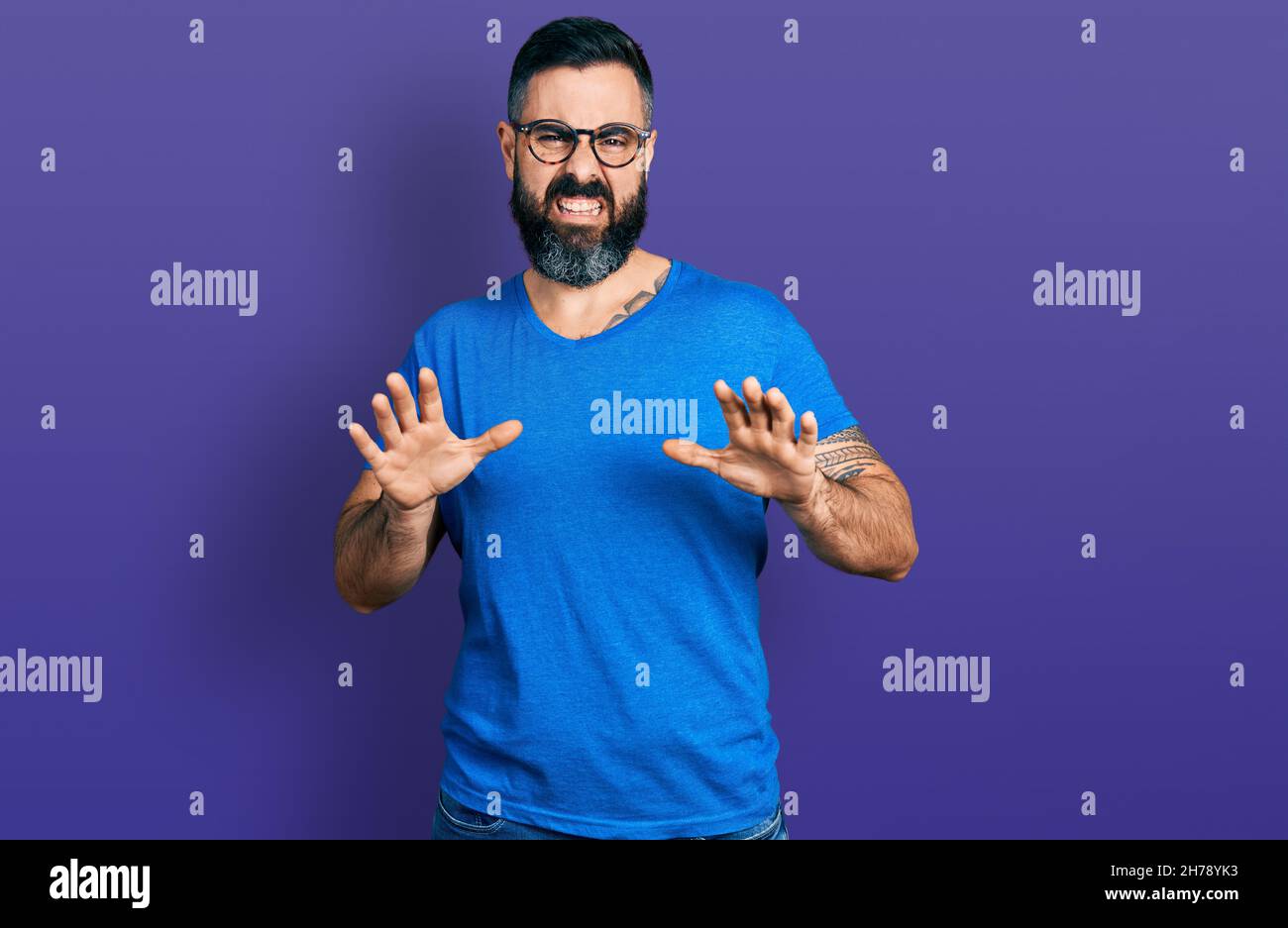 Hispanic man with beard wearing casual t shirt and glasses disgusted ...