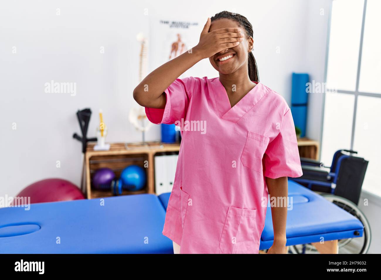 Young african american woman working at pain recovery clinic smiling ...