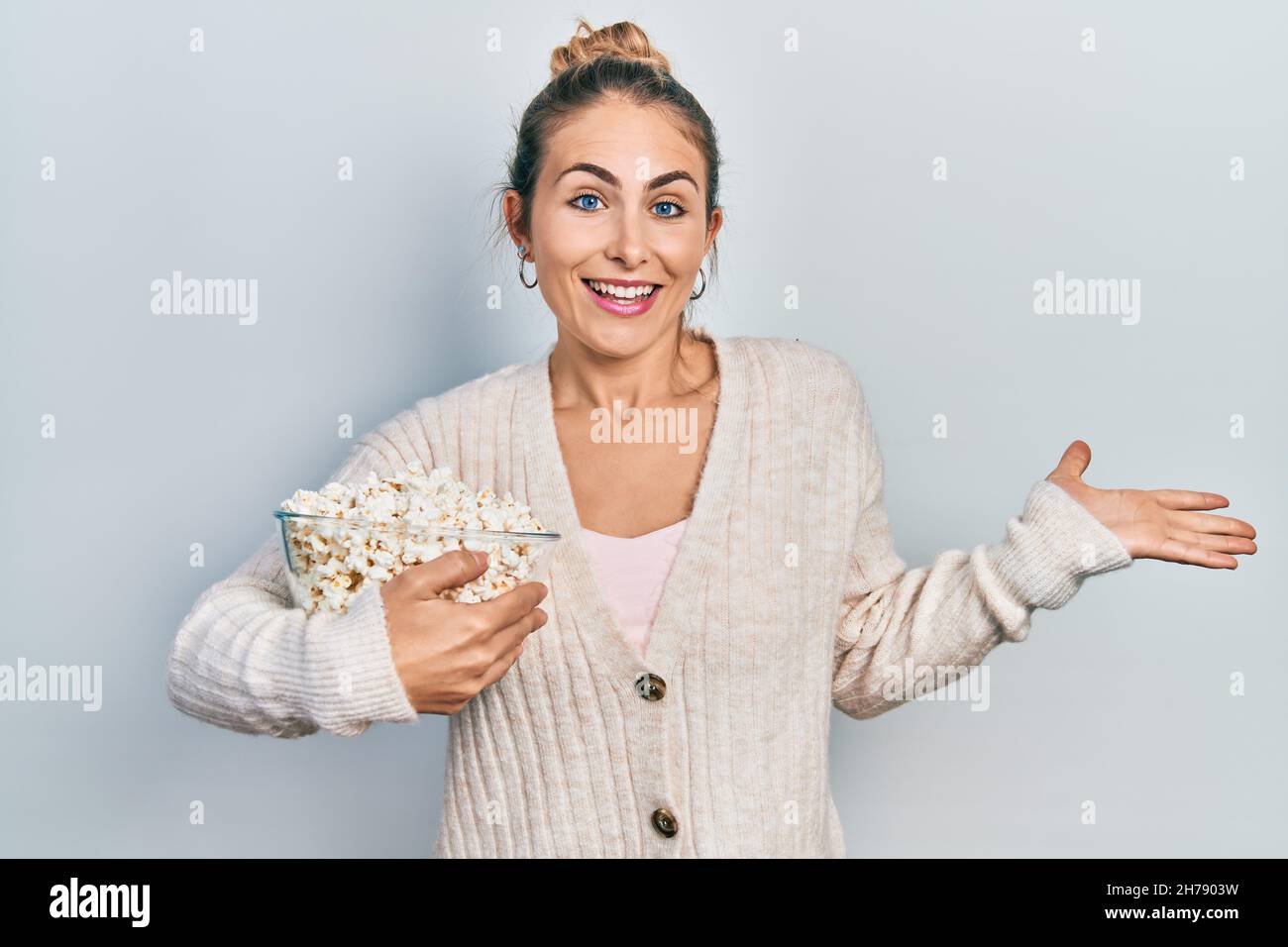 Young caucasian woman eating popcorn celebrating achievement with happy ...