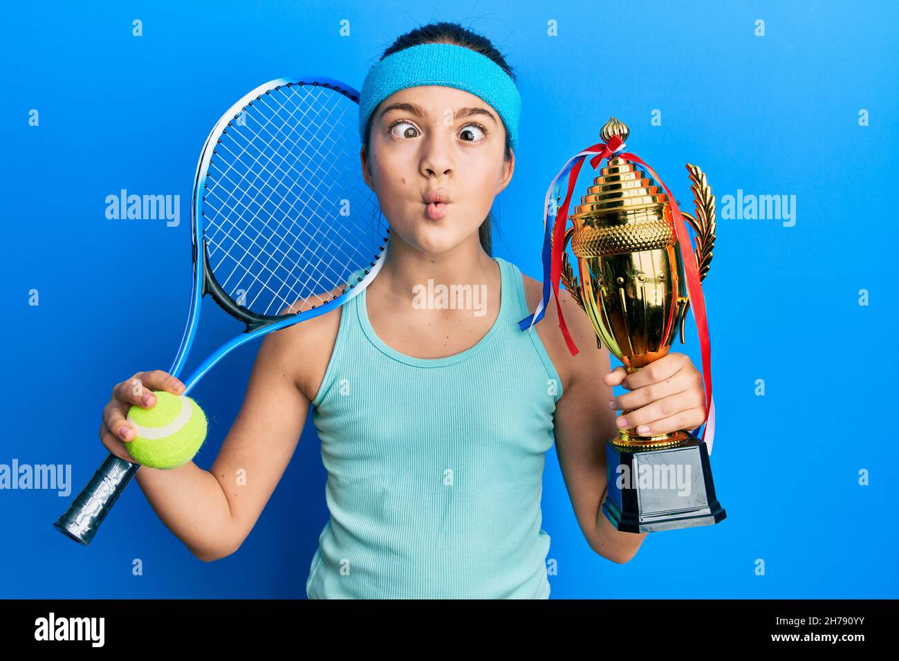 Beautiful brunette little girl playing tennis holding trophy making ...