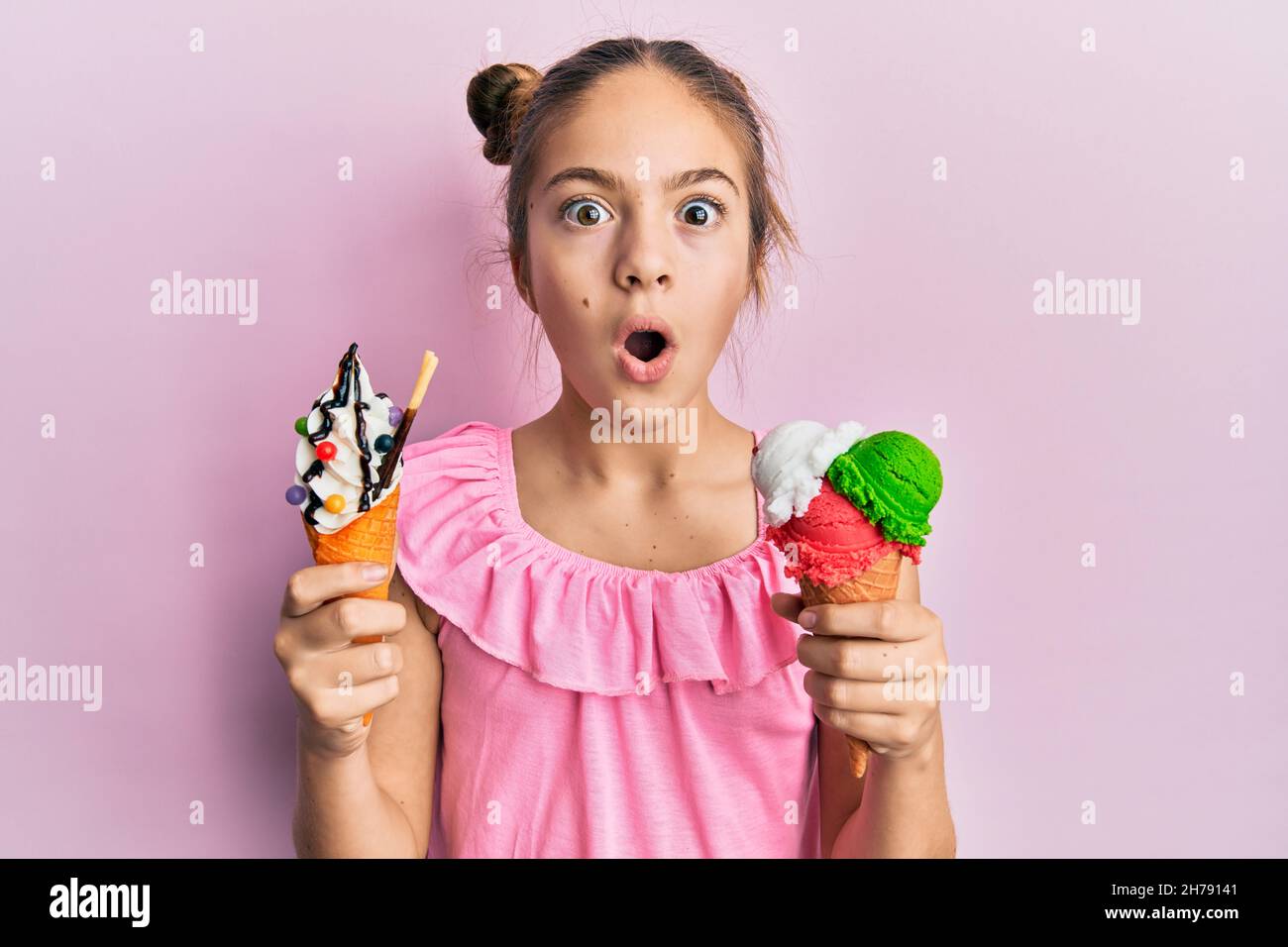 Beautiful brunette little girl eating ice cream cones afraid and ...