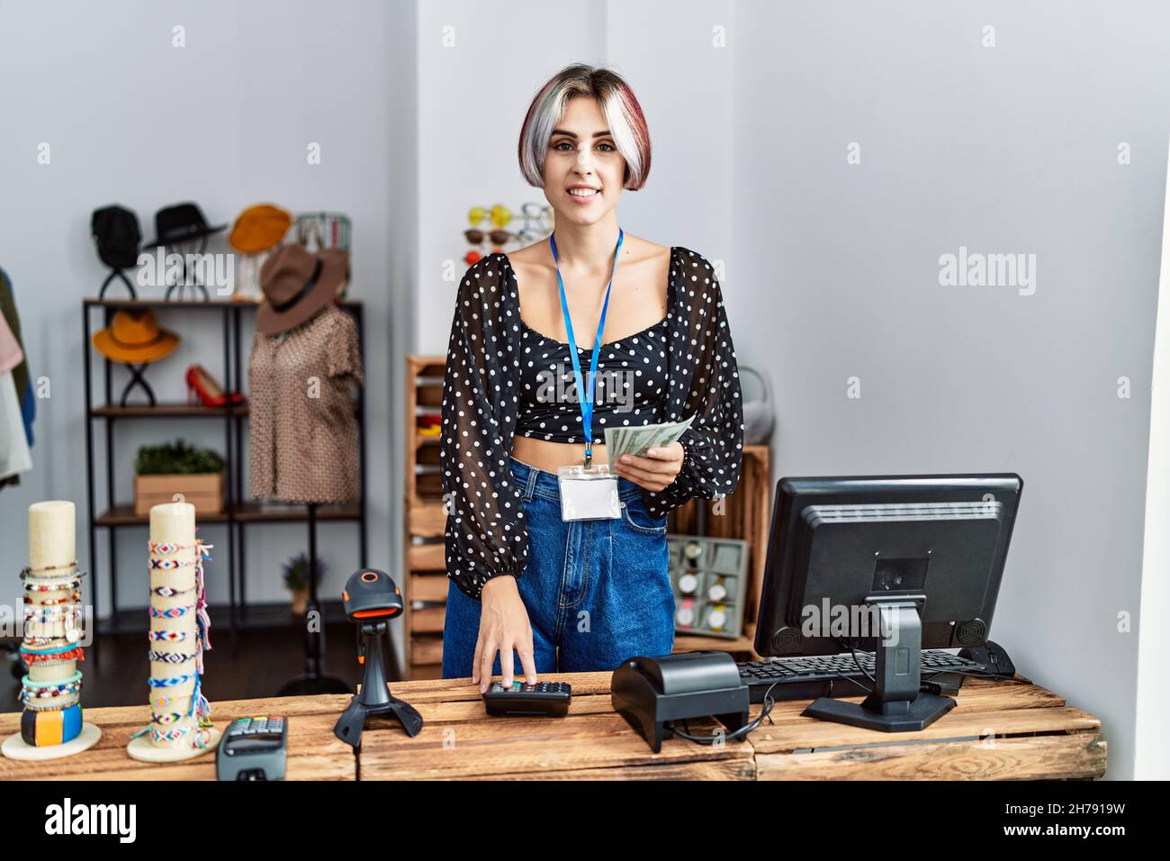 Young caucasian shopkeeper woman calculate price holding dollars at ...
